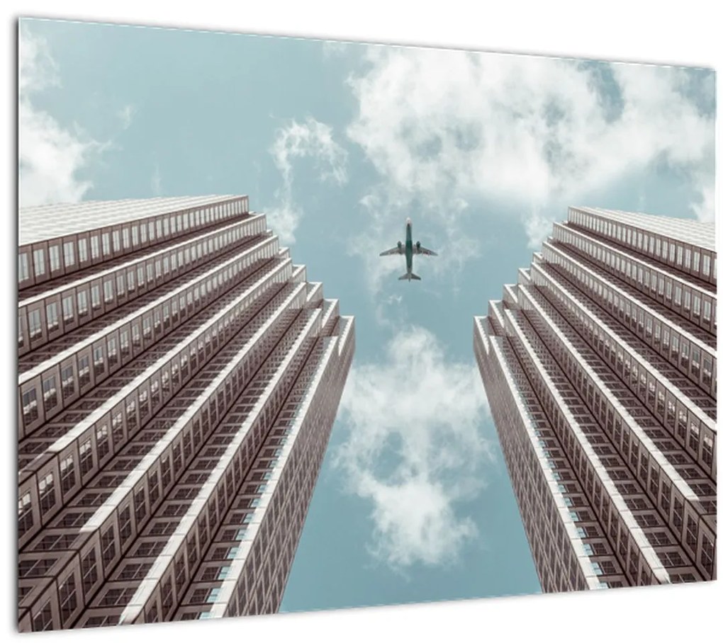Skleněný obraz letadla mezi budovami (70x50 cm)