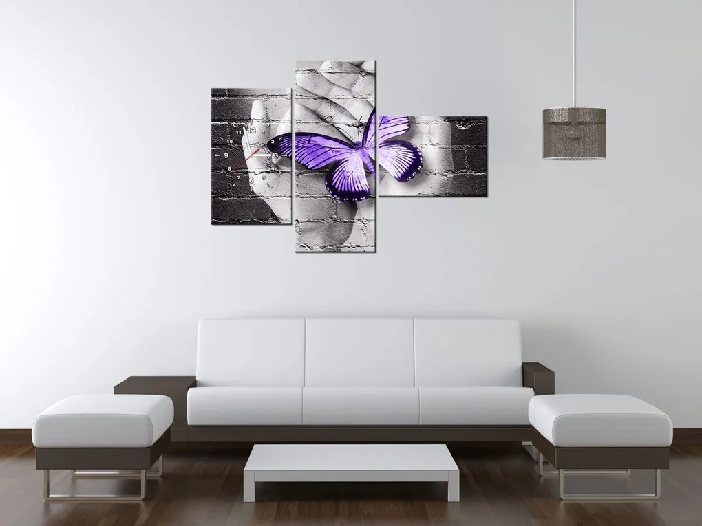Gario Obraz s hodinami Fialový motýl na dlaních - 3 dílný Rozměry: 30 x 90 cm