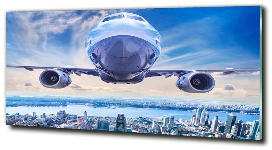 Wallmuralia Moderní skleněný obraz z fotografie Letadlo na městem 125x50 cm