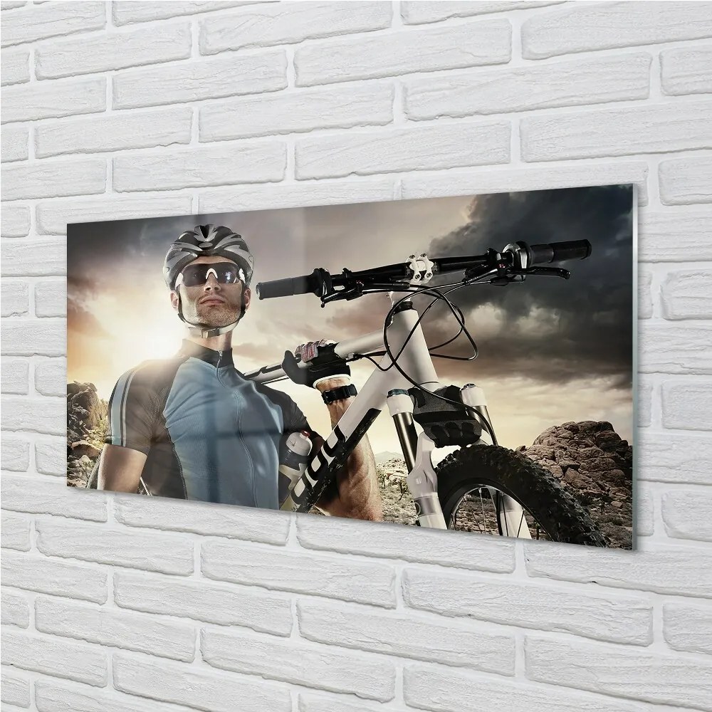 Obraz na skle Cyklista na kole mraky 120x60 cm