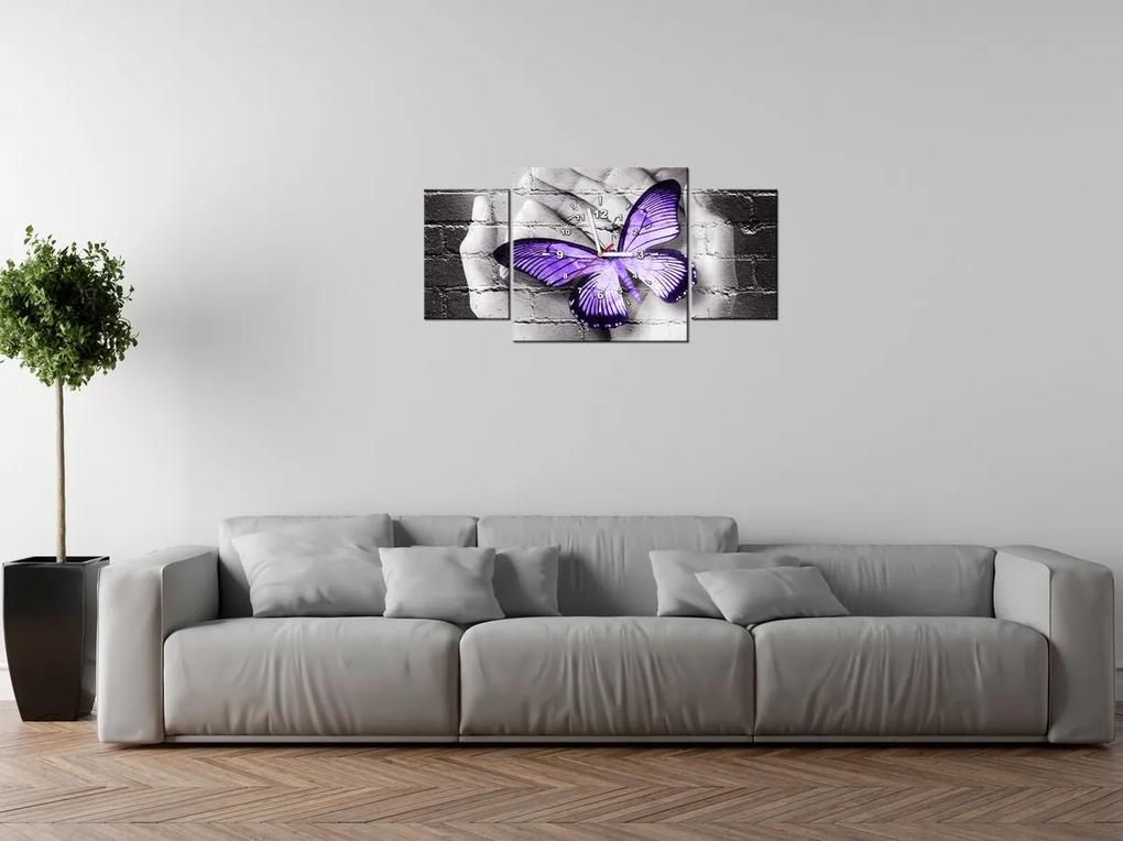 Gario Obraz s hodinami Fialový motýl na dlaních - 3 dílný Rozměry: 80 x 40 cm