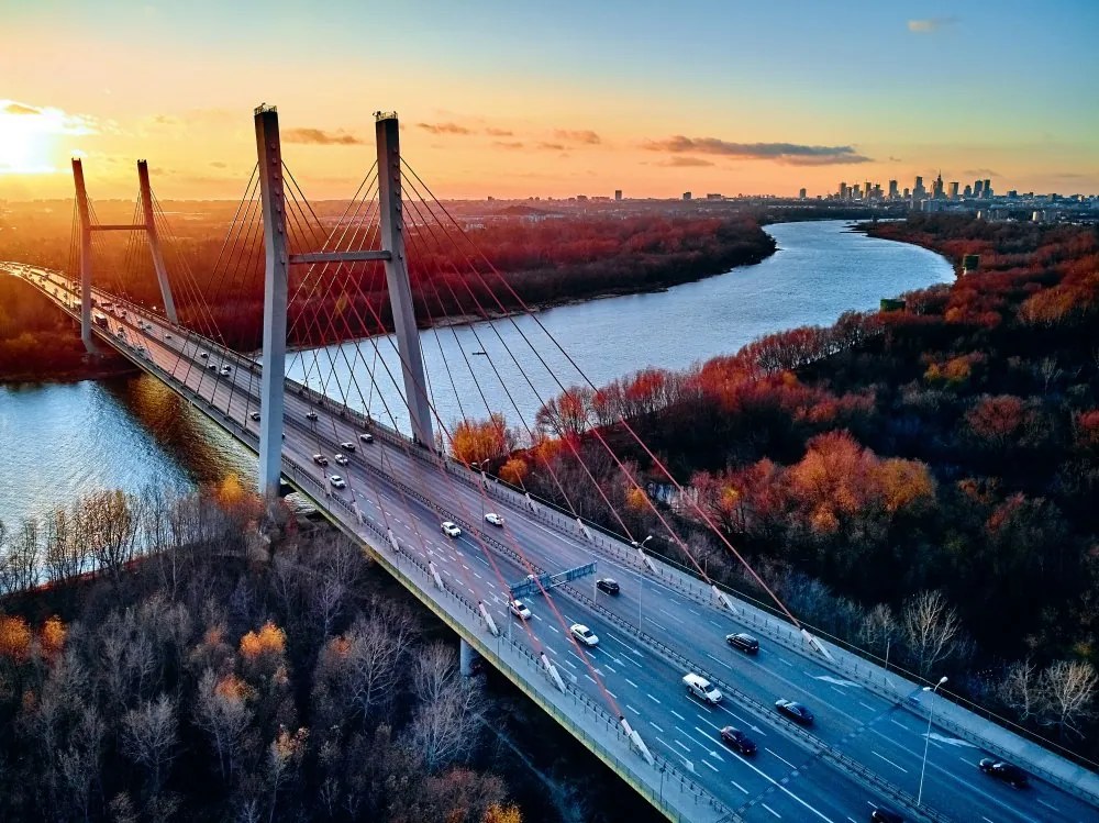 Fototapeta Beautiful Panoramic Aerial Drone View To Cable-Stayed Siekierkowski Bridge Over The Vistula River And Warsaw City Skyscrapers, Poland In Gold Red Autumn Colors In November Evening At Sunset Omyvatelný vlies 368x254