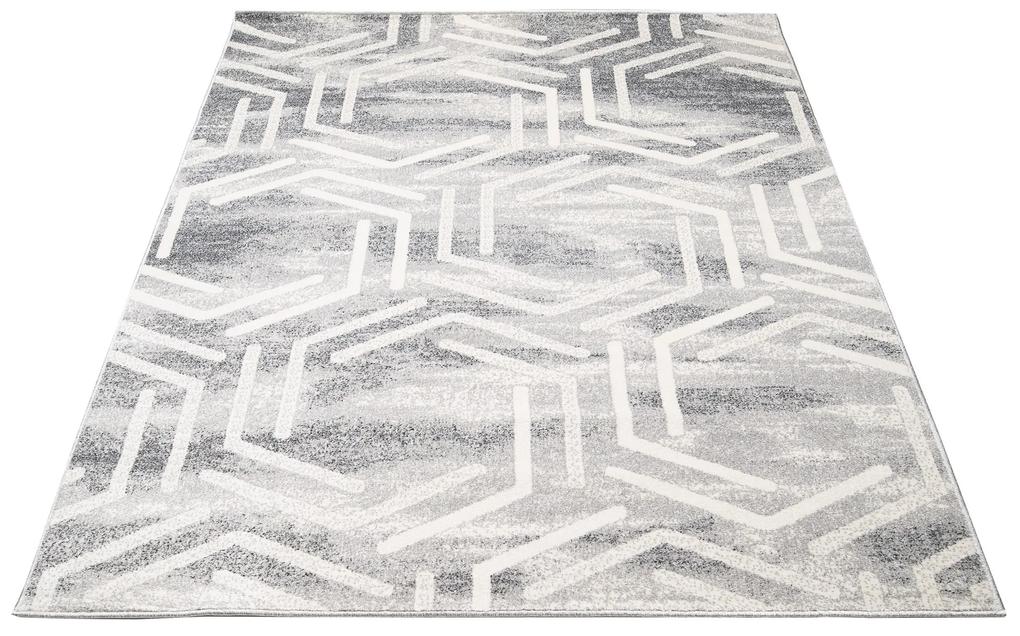 Světlý designový koberec s geometrickým vzorem