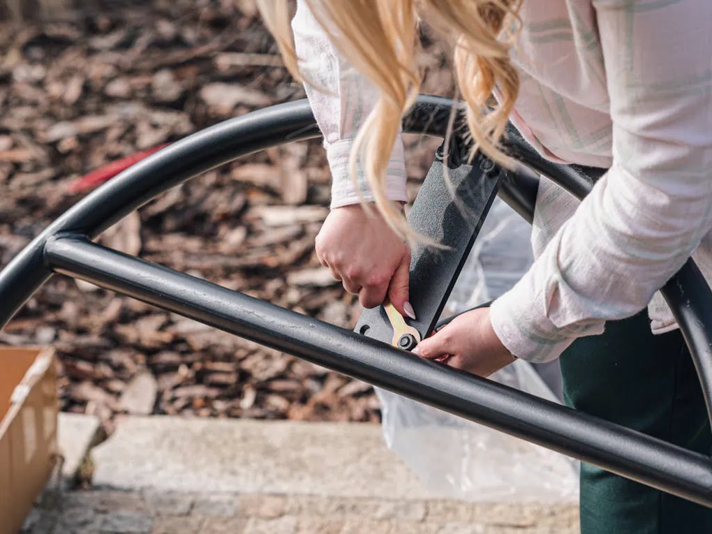 Světle šedé závěsné křeslo TROPIKAL s černým stojanem