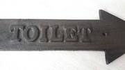 Litinová cedule nástěnná šipka Toilet - 29*10*1 cm