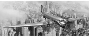 DIMEX | Panoramatická vliesová fototapeta na zeď Letadlo nad městem MP-2-0006  | 375 x 150 cm | černobílá