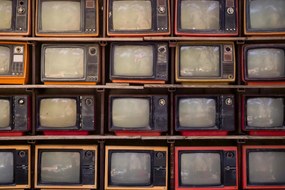 DIMEX | Vliesová fototapeta Zeď starých televizorů MS-5-2161 | 375 x 250 cm| červená, černá, žlutá, oranžová, šedá