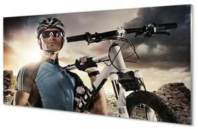 Obraz na skle Cyklista na kole mraky 100x50 cm