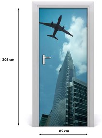 Fototapeta samolepící dveře letadlo nad městem 85x205 cm