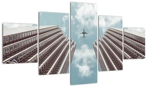 Obraz letadla mezi budovami (125x70 cm)