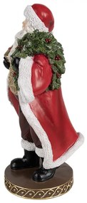 Červená vánoční dekorace Santa Claus na hnědém podstavci držící dárek a vánoční bobule – 23 cm